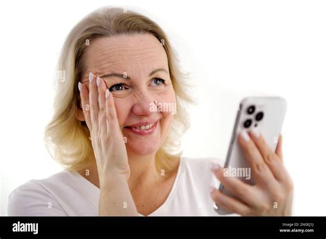 Constraint Phonel Woman Looks Into The Phone With Embarrassment Isolated On White Background