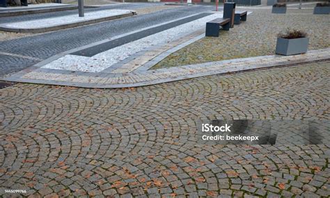 차선 사이에 섬을 나누는 보행자 횡단 거리를 따라 건조하고 사랑스러운 꽃으로 심어진 도로 표시가있는 아치 원예 호화로운 돌 연석과 산책로 포장 0명에 대한 스톡 사진 및
