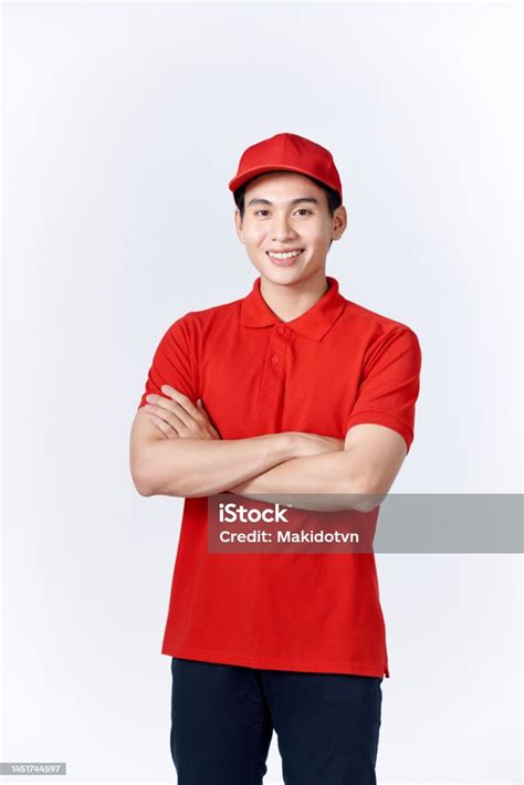 파란색 유니폼 교차 팔을 입고 자신감 있게 보이는 미소 짓는 아시아 배달원 도울 준비가 된 흰색 배경 고객에게 질서 제공 20 24세에 대한 스톡 사진 및 기타 이미지