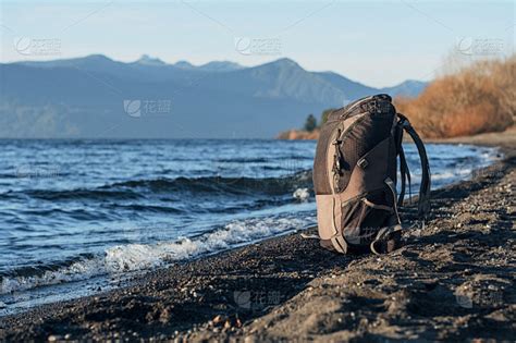 旅行者的背包放在湖边的地上。