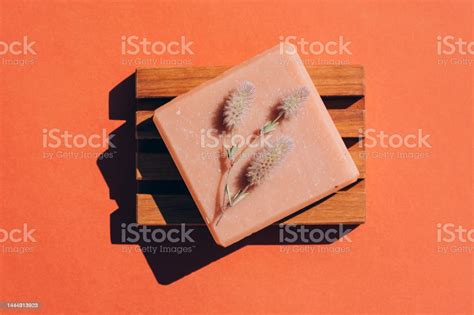 붉은 갈색 배경 위에 나무 비누 접시에 향기로운 허브가 있는 수제 비건 비누 바 집에서 천연 성분으로 허브 비누 만들기 평면도 플랫 레이 스타일 비누 접시에 대한 스톡 사진