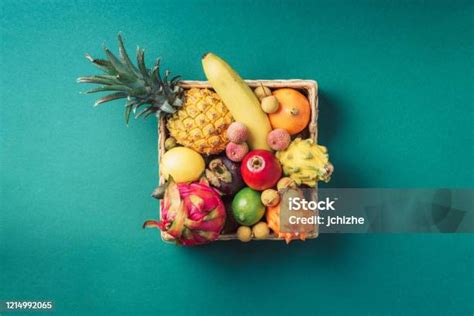 녹색 배경에 열대 과일입니다 이국적인 태국 과일의 전체 등나무 상자 파인애플 피타 하야 키와노 아프리카 뿔 멜론 타마릴로 과일 그라나딜라 페이조아 살락 뱀 과일 마라쿠야