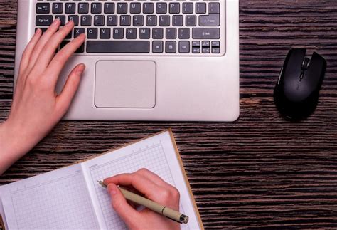 Premium Photo Wooden Desk With Laptop And Notepad On It Making Notes In Notebook