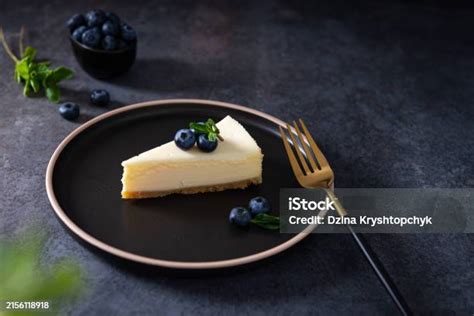 어두운 배경에 블루 베리와 민트를 곁들인 맛있는 수제 바닐라 치즈 케이크 조각 클래식 뉴욕 치즈 케이크 건강한 유기농 여름 디저트 측면도 복사 공간 과자 메뉴 레시피 그릇에