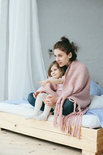 엄마와 그녀의 작은 딸 포옹 웃 고 분홍색 담요에 덮여 나무 침대에 앉아 공생 행복 한 가족의 날 개념입니다 2명에 대한 스톡 사진 및 기타 이미지 Istock
