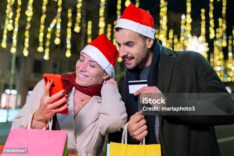연말연시 조명 아래에서 신용카드와 스마트폰으로 온라인 쇼핑을 하는 커플 2명에 대한 스톡 사진 및 기타 이미지 2명 Brand Name Smart Phone 가방