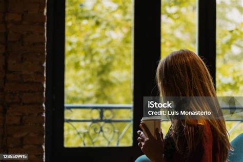 커피를 들고 창 밖으로 바라보는 안락의자에 앉아 있는 어린 금발 소녀 20 24세에 대한 스톡 사진 및 기타 이미지 20 24세 20 29세 금발 머리 Istock