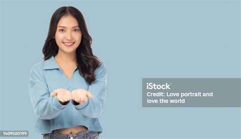 그녀의 손바닥에 상상의 복사 공간을 들고 광고 삽입 파셀 색상 배경 위에 서있는 젊은 아시아 여성 초상화 미소 얼굴로 뷰티 손바닥에 카피 스페이스를 들고 행복한 웃는 소녀