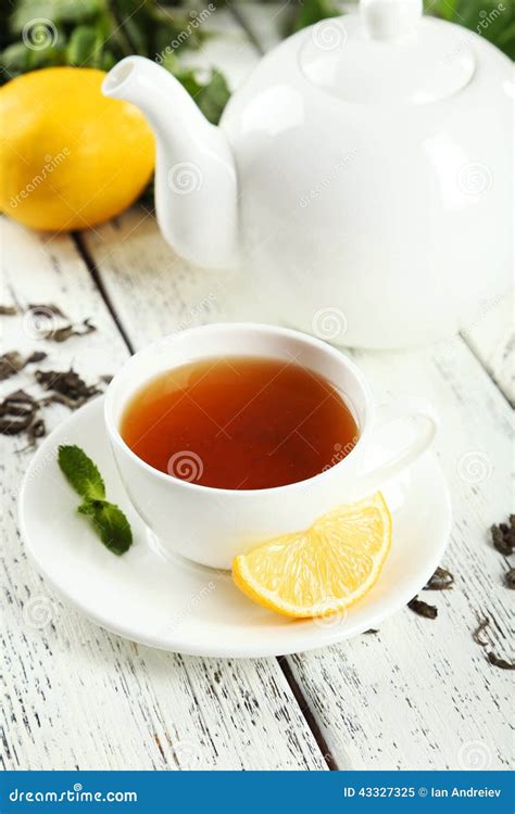 Зеленый чай в чашке и чайнике на белой деревянной предпосылке Стоковое Изображение изображение