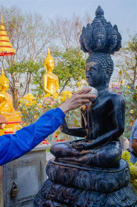 Premium Photo A Mans Hand Pours Holy Water On The Statue Of The