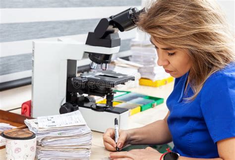 Pathologist Working With Stained Tissue Biopsy On Glass Slides In The