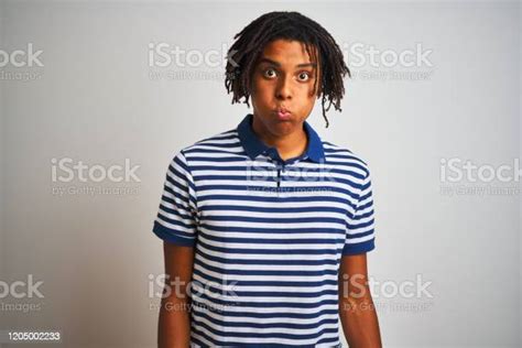 무서운 얼굴을 가진 아프로 남자 스트라이프 블루 폴로 를 입고 고립 된 흰색 배경 퍼핑 뺨 위에 서 재미있는 얼굴 공기 미친