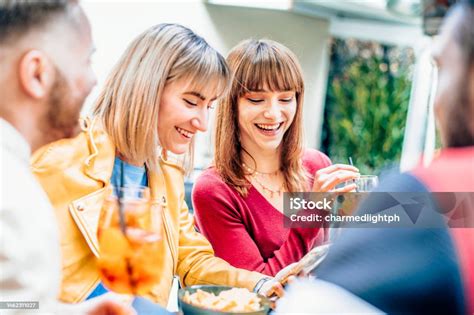 칵테일 바 레스토랑 뒤뜰에서 물을 마시는 사람들 함께 웃고 있는 두 소녀 펍에서 해피 아워에 함께 술을 마시는 어린 친구들과