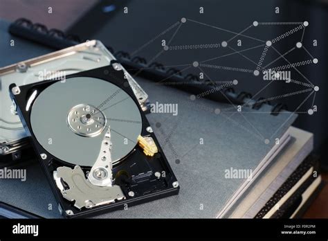 Close Up Of Open Computer Hard Disk Drive With Social Network Diagram On Desk And Notebook Stock