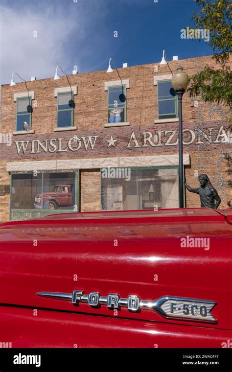 Red Ford Flatbed Truck Wit Statue Of Glenn Frey Standing On A Corner