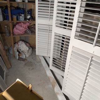 The Inside Of A Storage Room With White Shutters