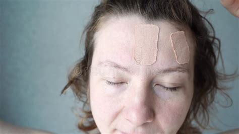 Female Adult Caucasian Applying Facial Patches For Forehead Wrinkles In Skincare Stock Video