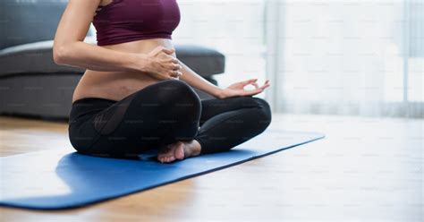 거실에서 요가 필라테스 운동을 하는 아시아 젊은 임산부 매력적인 아름다운 임산부는 운동복을 입고 행복을 느끼고 집에서 건강 관리를 위해 운동하는 동안 휴식을 취합니다