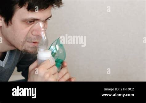 Use Nebulizer And Inhaler For The Treatment Young Man Inhaling Through