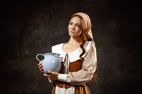 빈티지 스타일 어두운 배경에 고립 된 르네상스 시대의 소녀처럼 긴 곱슬 머리를 가진 젊은 매력적인 빨간 머리 소녀 시대 비교 아름다움 예술 그림 신데렐라에 대한 스톡 사진