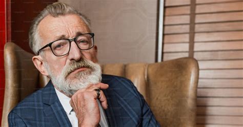 진지한 집중 노인 남성은 안경과 정장 파란색 양복을 입고 주름지고 경험 많은 얼굴로 식당에 앉아 있는 동안 놀라운 삶의 순간을 기억합니다 사진 Unsplash의 양복 이미지