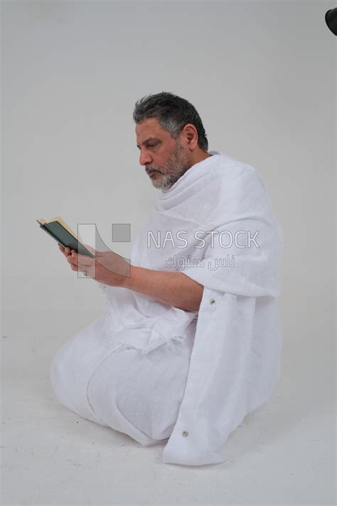 Saudi Man Wearing The Ihram Dress And Holding The Holy Quran Book