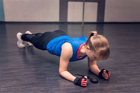 그의 손에 서 있는 흰 머리를 가진 소녀 지구력 훈련 선수는 타이머 또는 스톱 워치를 본다 시간에 대 한 운동 아름 다운 스포티 한 젊은 여성이 하 고 밀어 업에 피트 니스