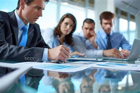 Premium Photo Group Of Executives Around A Table Analyzing Performance Metrics And Operational