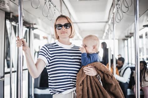 Mãe Carrega Seu Filho Em Pé E Segura No Suporte Da Barra No ônibus