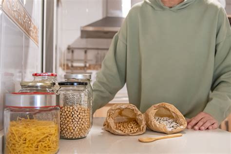 벌크 품목을 수집하여 유리 용기에 밀봉하는 사람 매일 구매를 위해 친환경 종이 봉지를 사용하는 익명의 쇼핑객 환경을 생각하는 사람 0에 대한 스톡 사진 및 기타 이미지