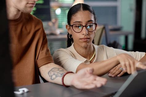 Portrait Of Female It Programmer Helping Male Colleague While Collaborating In Office Stock