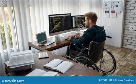 Full Concentration Back View Of Young Professional Web Developer In A Wheelchair Writing