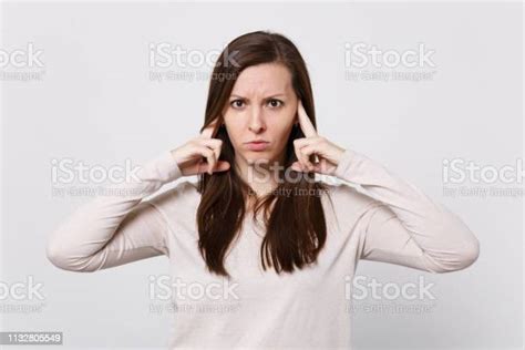 스튜디오에서 흰색 벽 배경에 고립 된 손가락으로 귀를 덮는 카메라를 찾는 가벼운 옷에 관련 된 젊은 여자의 초상화 사람들은 진심으로 감정 라이프 스타일 개념입니다 복사