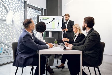 성공적인 사업가는 현대 사무실에서 집중 된 다인종 동료들과 함께 일하면서 분석 보고서를 발표합니다 팀워크 및 브레인스토밍 교육에 대한 스톡 사진 및 기타 이미지 Istock