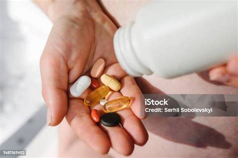 흰 병으로 보충제의 근접 촬영 사진 임산부는 오메가 3 종합 비타민 비타민 B C D 콜라겐 정제 프로바이오틱스 철분 캡슐을 섭취합니다 소녀는 매일 비타민을 들고 있습니다