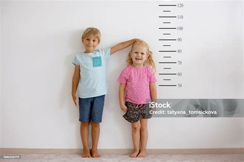 어린 아이들 금발의 소년과 소녀 방 벽에 기대어 높이를 측정하다 2명에 대한 스톡 사진 및 기타 이미지 2명 가득 찬 귀여운 Istock