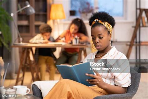 작은 테이블과 독서 책으로 회색 안락 의자에 앉아있는 젊은 아프리카 여성 읽기에 대한 스톡 사진 및 기타 이미지 읽기 책 여자만 Istock