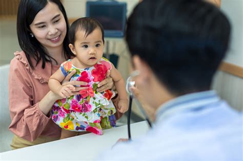 청진기를 사용하여 의사가 검사하는 아기 소아과 의사 의사는 심장 박동을 검사하는 청진기로 아기를 검사 할 준비를합니다 아기에