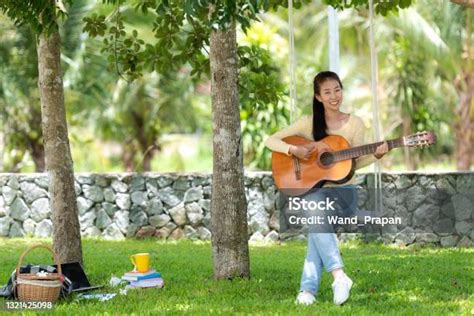 아침에 노트북에서 작업하고 교육을 받은 후 기타를 연주하고 커피를 마시는 젊은이들이 자연 정원 집에서 휴식을 취합니다 25 29세에 대한 스톡 사진 및 기타 이미지 Istock