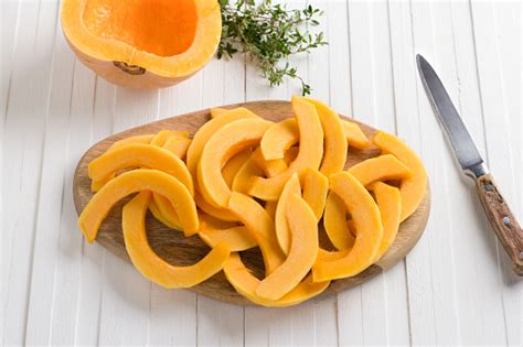 얇게 썬 호박 씨앗이 없는 반 껍질을 벗긴 호박 흰색 배경에 백리향과 부엌 칼이 있는 나무 보드 평면도 맛있는 수제 음식 요리하기 10월에 대한 스톡 사진 및 기타 이미지