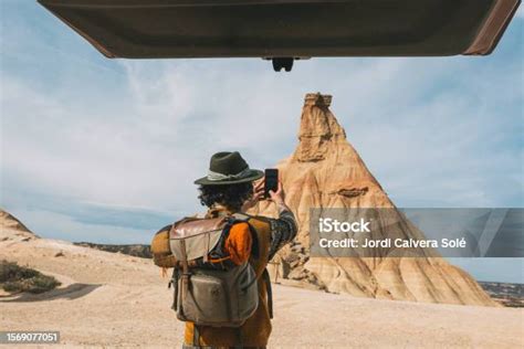 Bardenas 사막에서 그의 밴에서 스마트 폰으로 사진을 찍는 모자를 쓴 남자의 뒷모습 나바라 보기 정적 활동에 대한 스톡 사진 및 기타 이미지 Istock