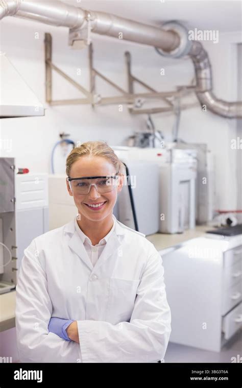 Female Lab Technician Wearing Lab Coat And Gloves Operating Analytical Instruments At Lab Bench