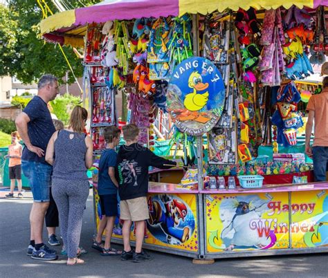 Group Of Individuals Near A Vibrant Outdoor Candy Booth On The Sidewalk