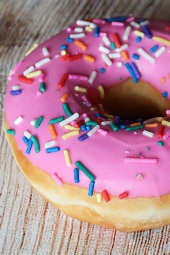 개인 핑크 퐁당 아이스 링 도넛 튀긴 반죽 디저트의 클로즈업 이미지 여러 가지 빛깔의 수백 수천 설탕 스프링클 나뭇결 배경 높은 전망 0명에 대한 스톡 사진 및 기타 이미지