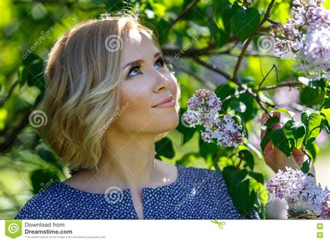 Glimlachend Mooi Jong Blond Meisje Dichtbij Lilac Struik Stock Foto Image Of Nave Bladeren