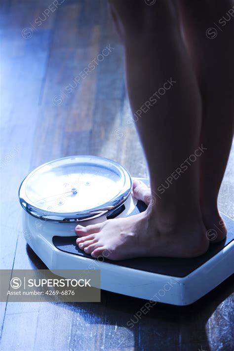 Woman Checking Her Weight On A Scale SuperStock