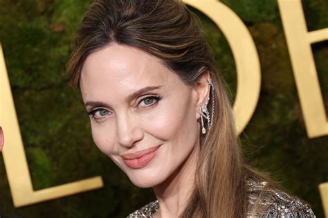 Джолі в срібній сукні з китицями та з 19 річною дочкою у чорно білому попозувала на хіднику