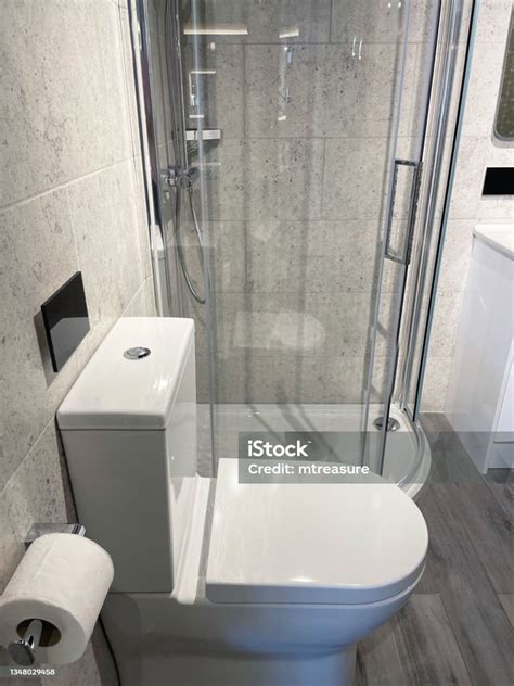 별도의 곡선 샤워 칸막이 슬라이딩 패널 유리 문 부드러운 닫기 시트 뚜껑바닥 흰색 화장실 크롬 변기 롤 홀더와 현대적인 샤워 룸 스위트의 이미지 배수관에 대한 스톡 사진 및