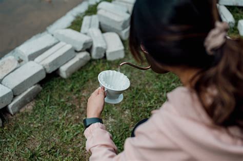 끓는 주전자에서 뜨거운 물을 붓는 여자를 닫아 캠프장에서 드립 커피를 만들 준비를하십시오 20 24세에 대한 스톡 사진 및 기타 이미지 20 24세 갈색 관광객