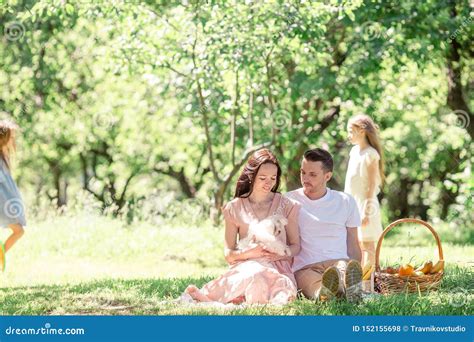 Счастливая семья на пикнике в парке на солнечный день Стоковое Фото изображение насчитывающей